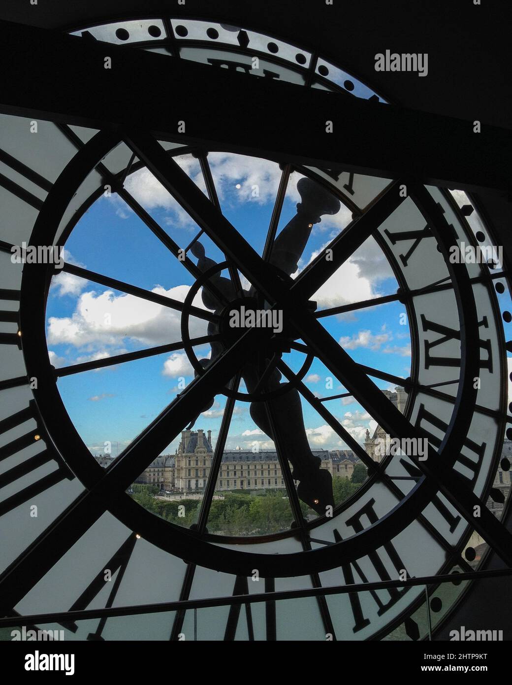 Vertical shot of a view of the Louvre and and a blue sky from a clock ...