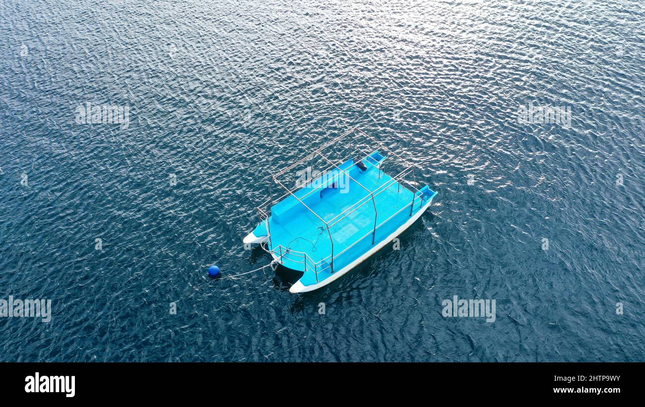 Aerial drone top down photo of small Catamaran anchored on deep blue ...