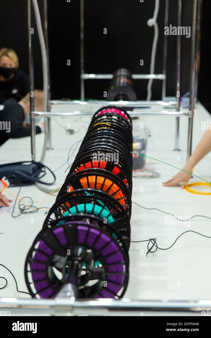 Colorful rainbow plastic filaments on bobbins and some 3D pens laying ...