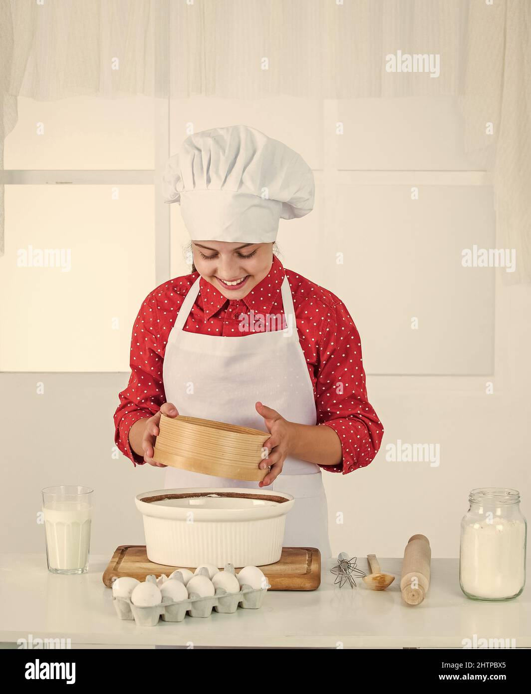 Look whats cooking. happy teen girl cooking dough. kid in chef uniform ...