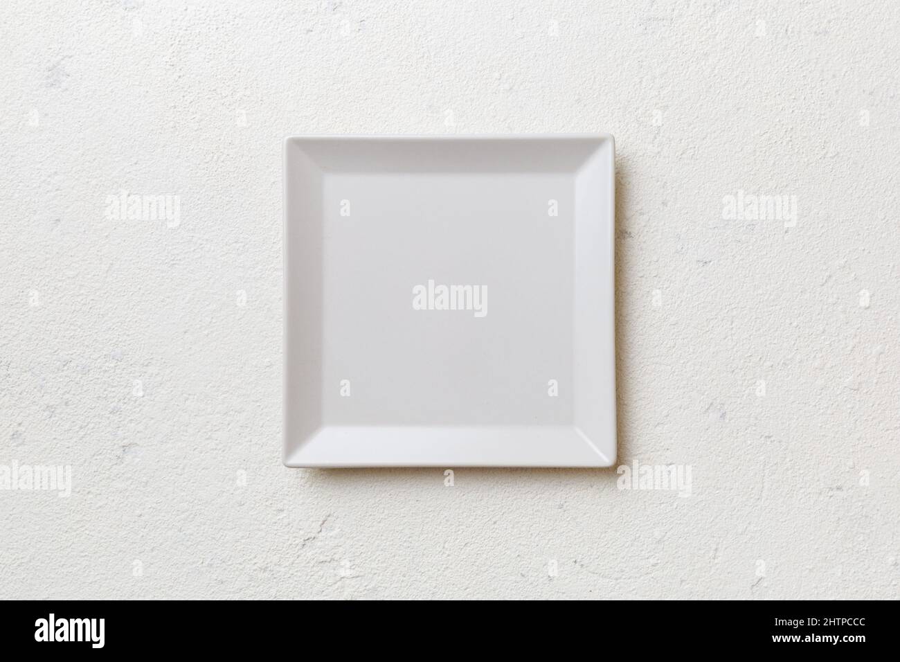 Top view of empty square plate on cement background. Empty space for ...