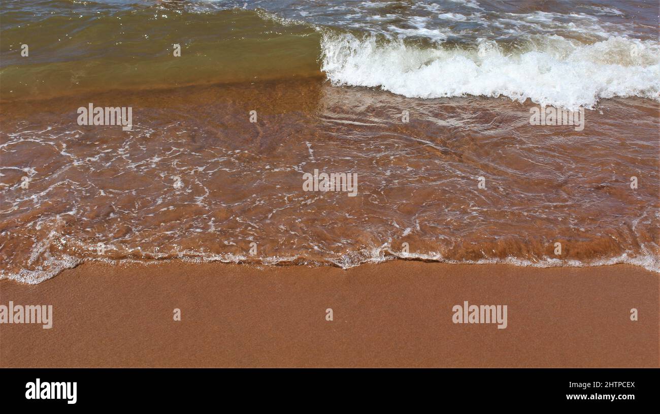 wave breaking on the red sand shore (PEI, Canada Stock Photo - Alamy