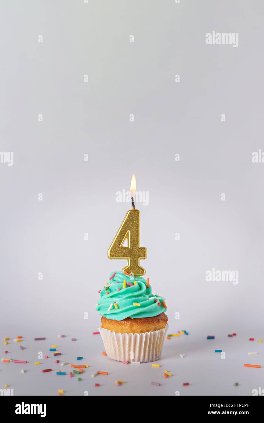 Homemade cupcake with colorful sprinkles and a candle in the shape of ...