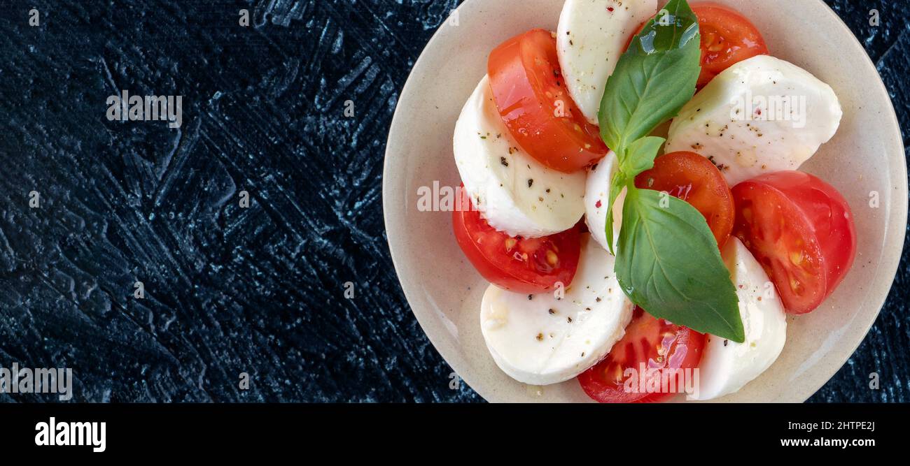 banner with close-up of tomato and mozzarella circles with basil leaf ...