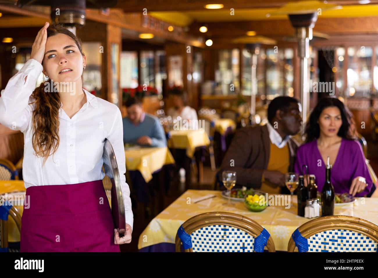 Portrait of tired waitress in restaurant Stock Photo - Alamy
