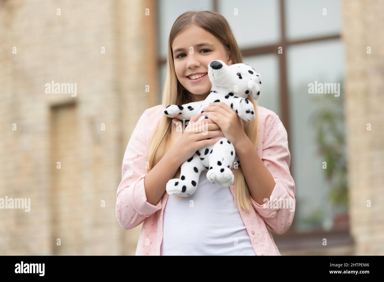 Happy girl child cuddling fluffy toy outdoors, childhood Stock Photo ...