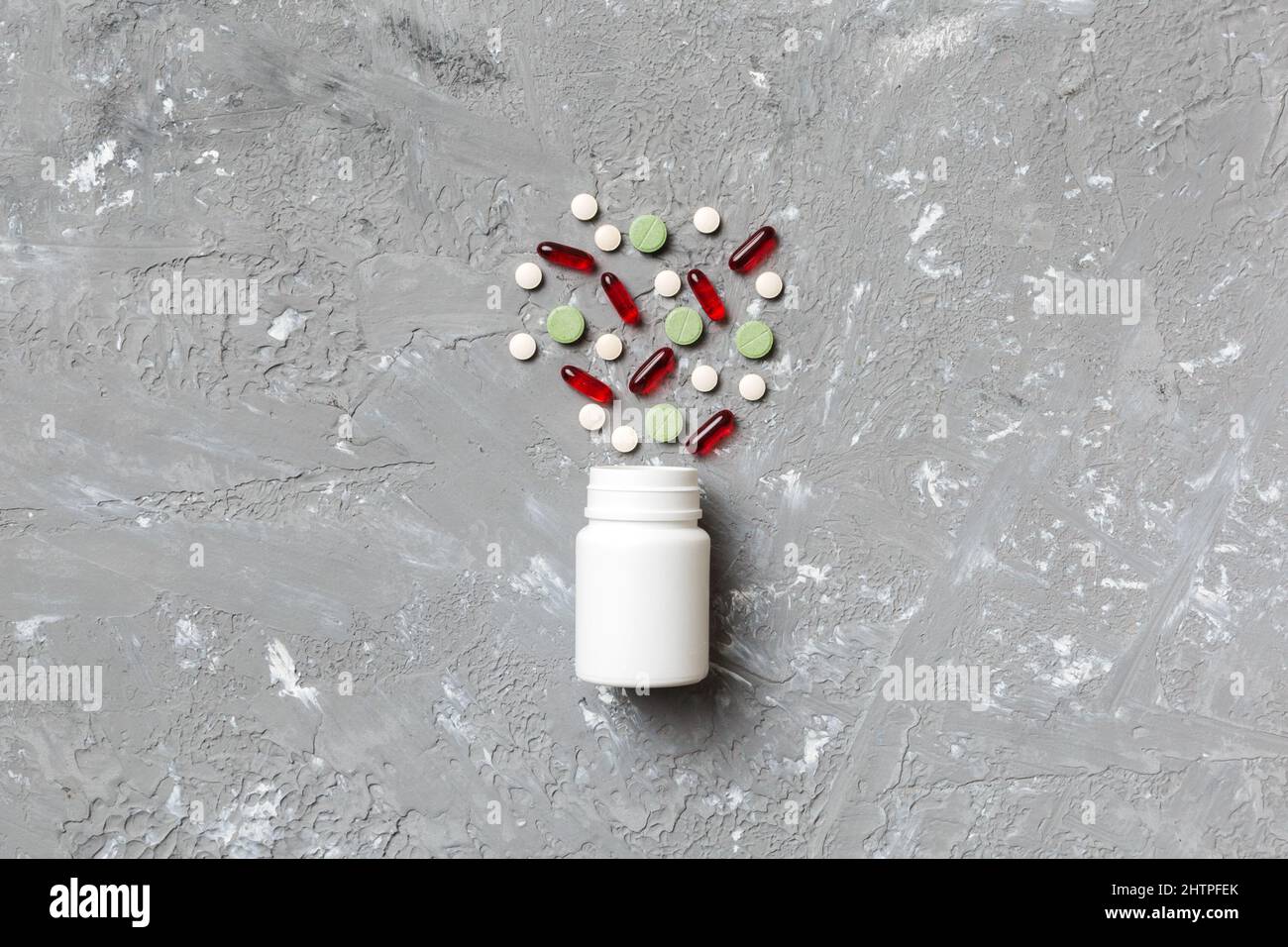 Multicolored pills and capsules in plastic bottle on Colored background ...