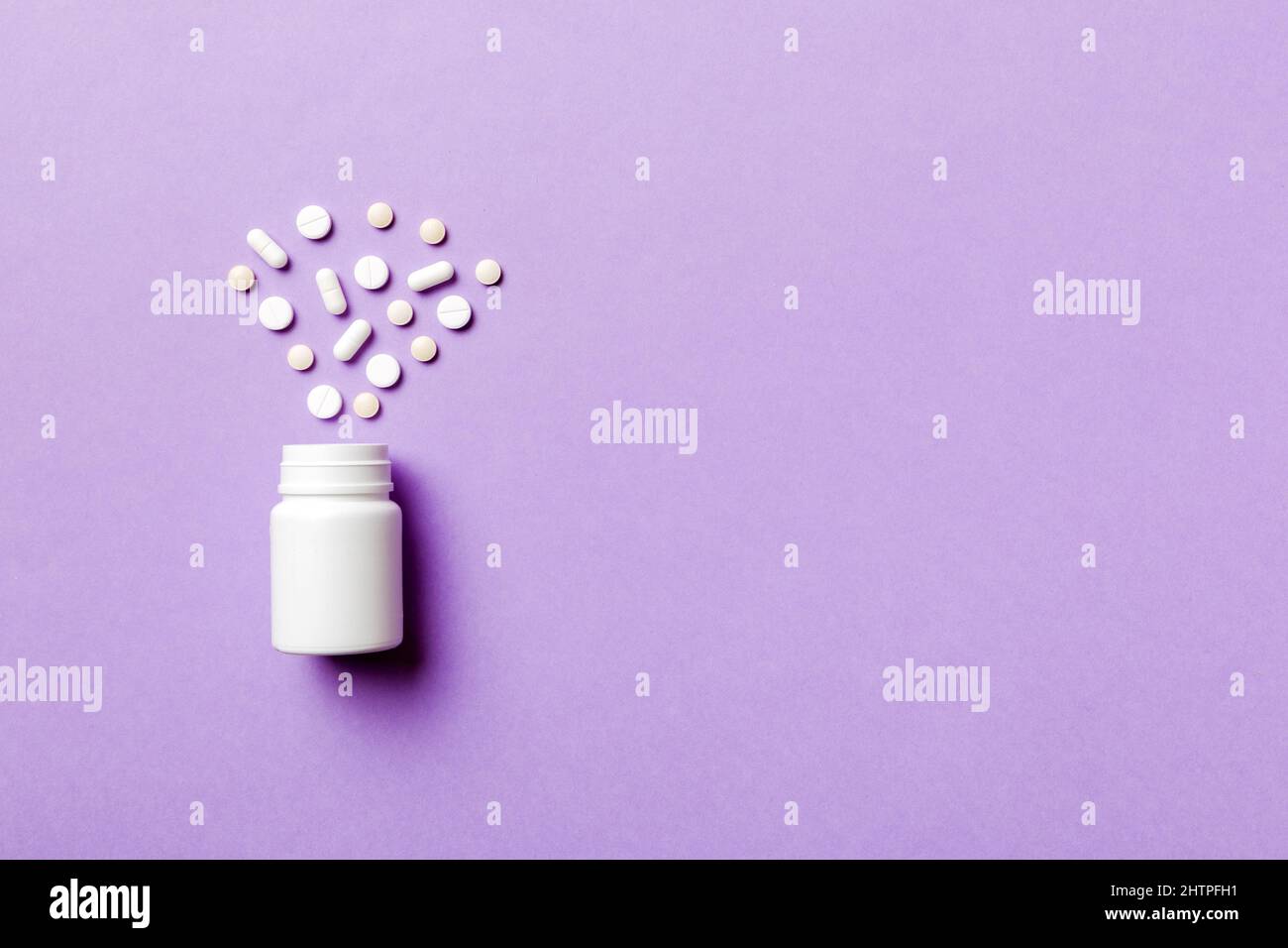 Multicolored pills and capsules in plastic bottle on Colored background ...