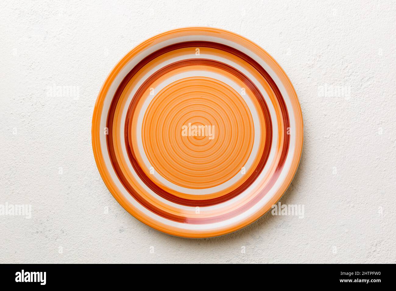 Top view of empty orange plate on cement background. Empty space for ...