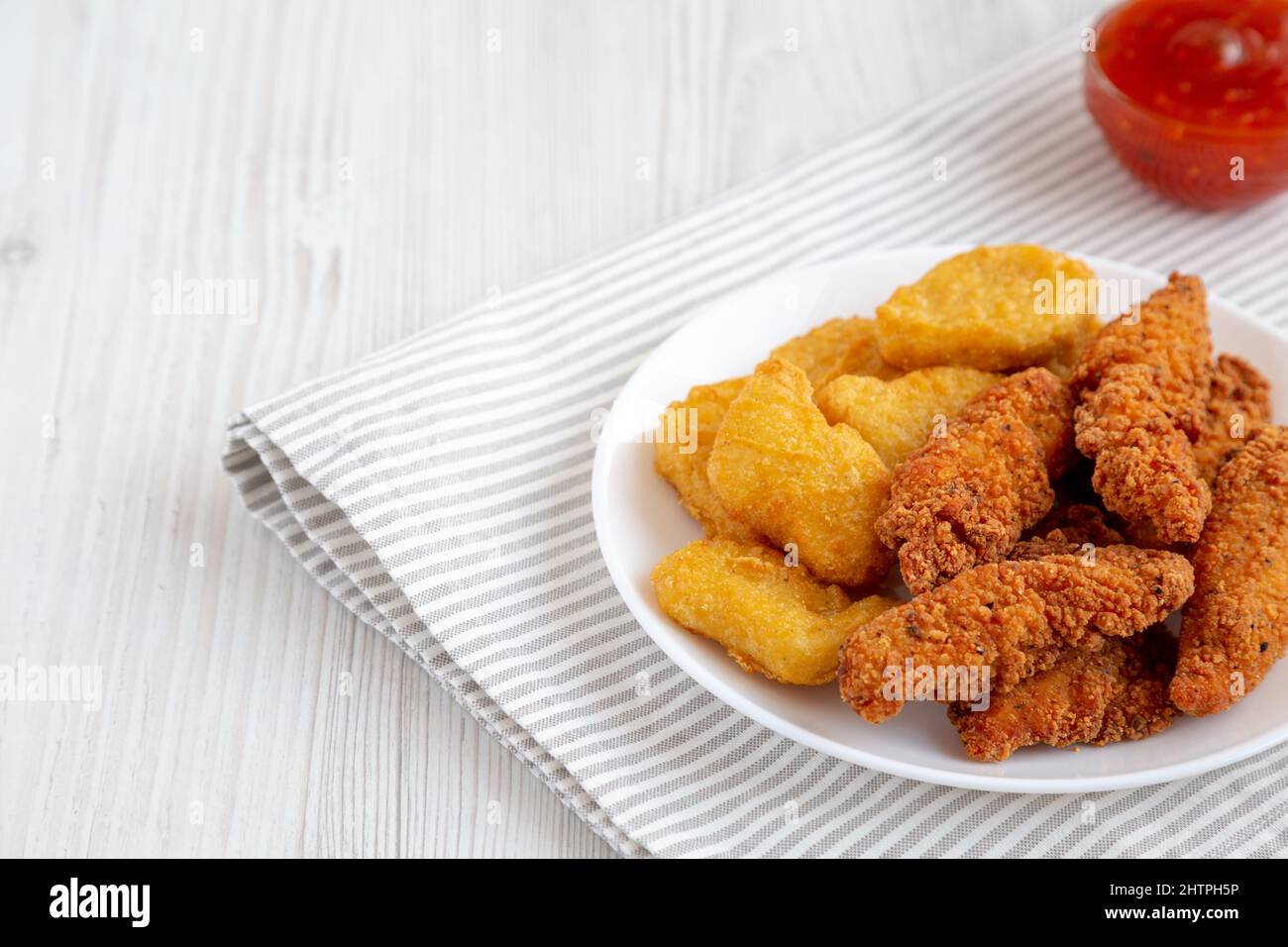 Homemade Nuggets And Chicken Tenders With Sweet And Sour Sauce On A White Wooden Background