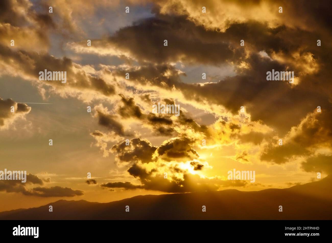 Sun breaking through clouds over city hi-res stock photography and ...