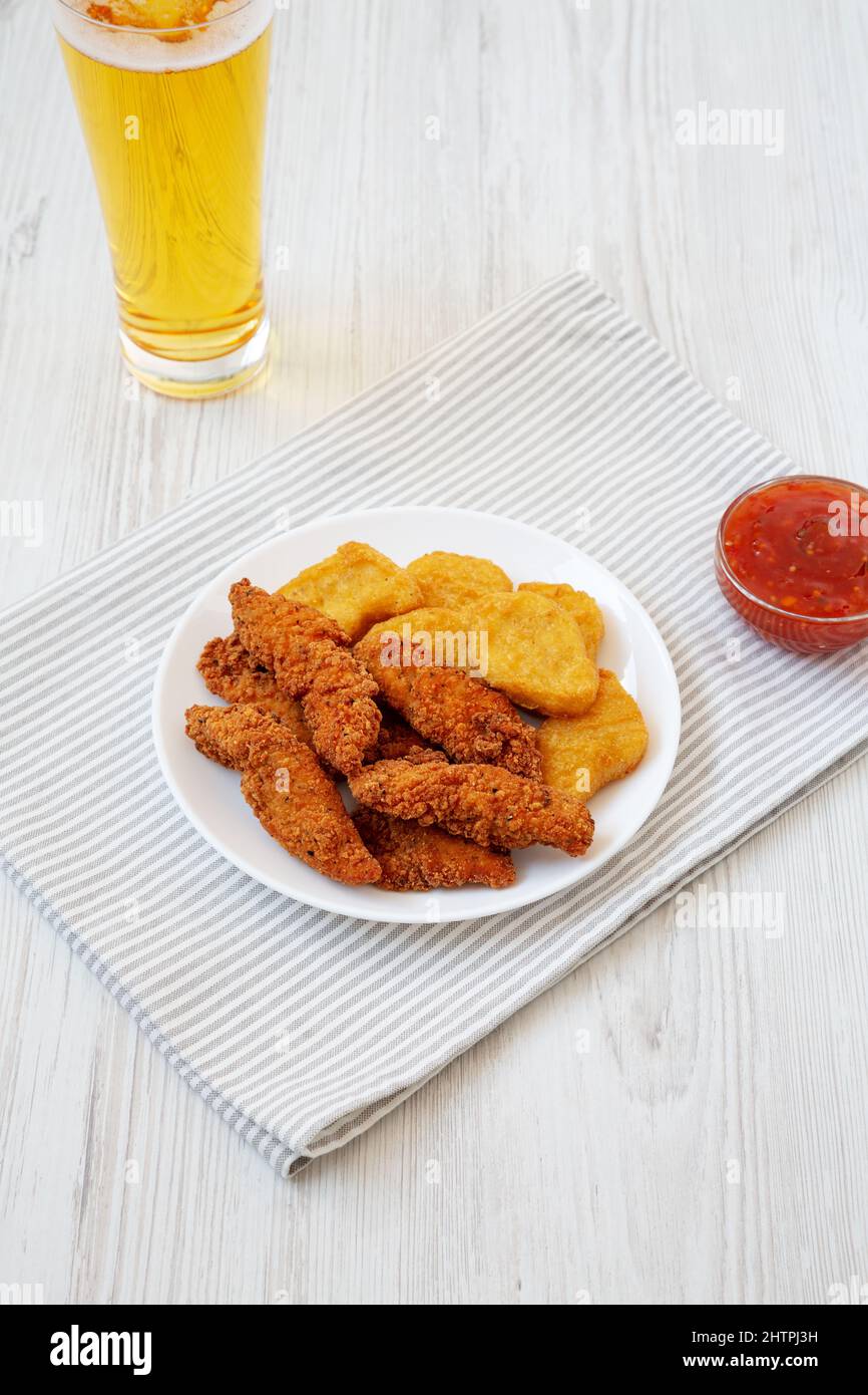 Homemade Nuggets and Chicken Tenders with Sauce and cold Beer, side ...