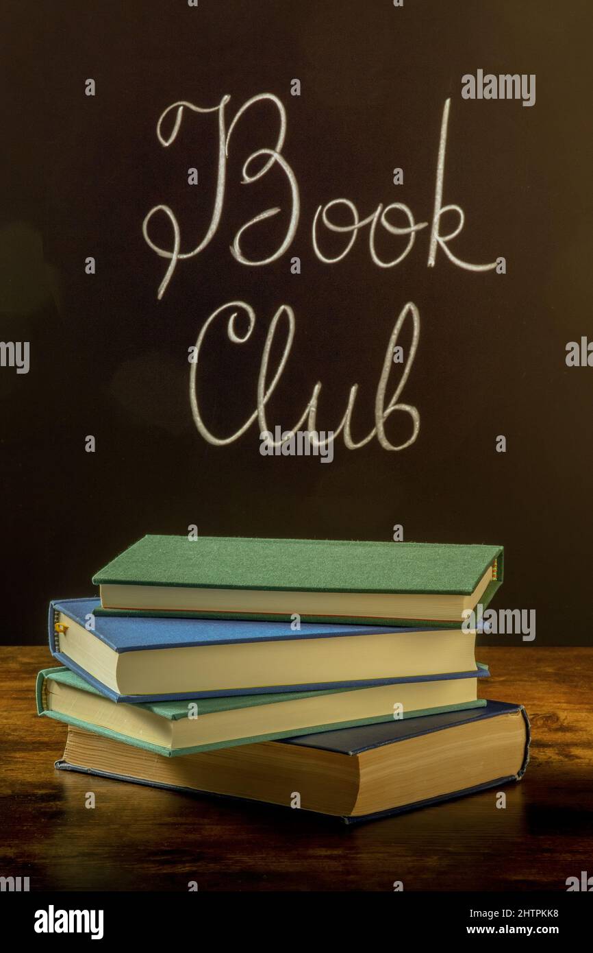 Book Club, toned image. A stack of books with chalk lettering on a ...