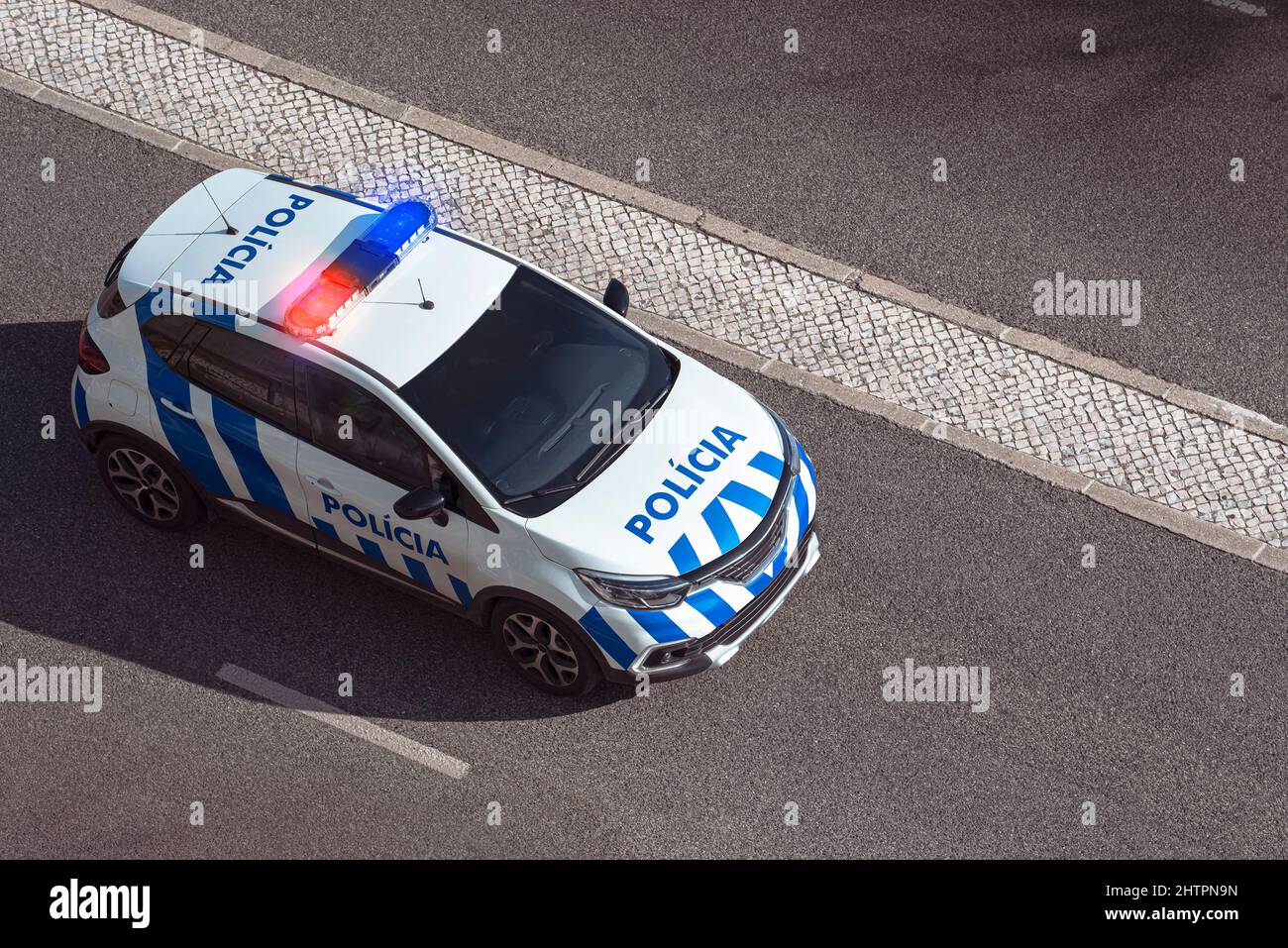 Policía means police, police car on the road with alarm and red and ...