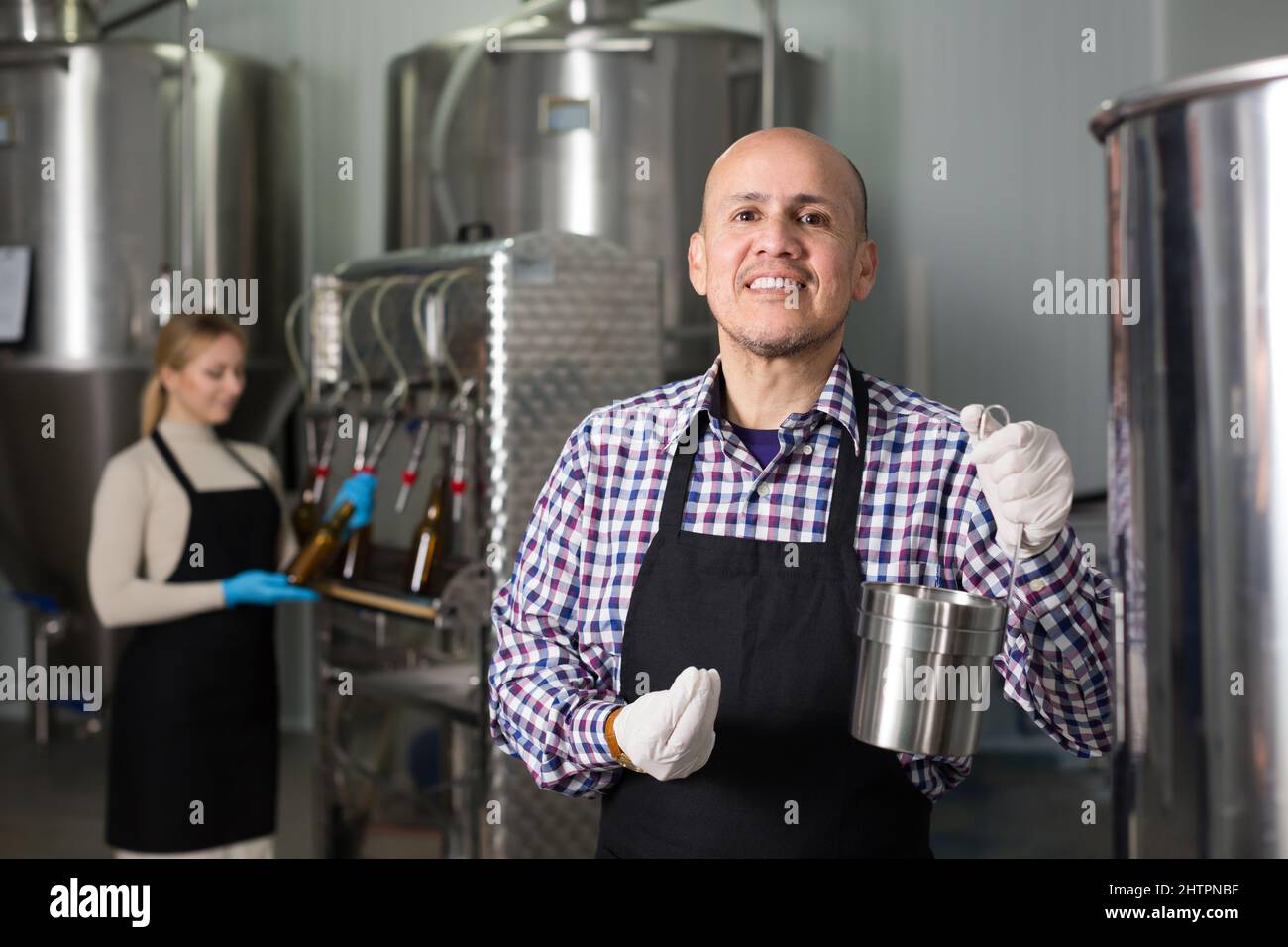Portrait of adult positive male brewery worker Stock Photo - Alamy