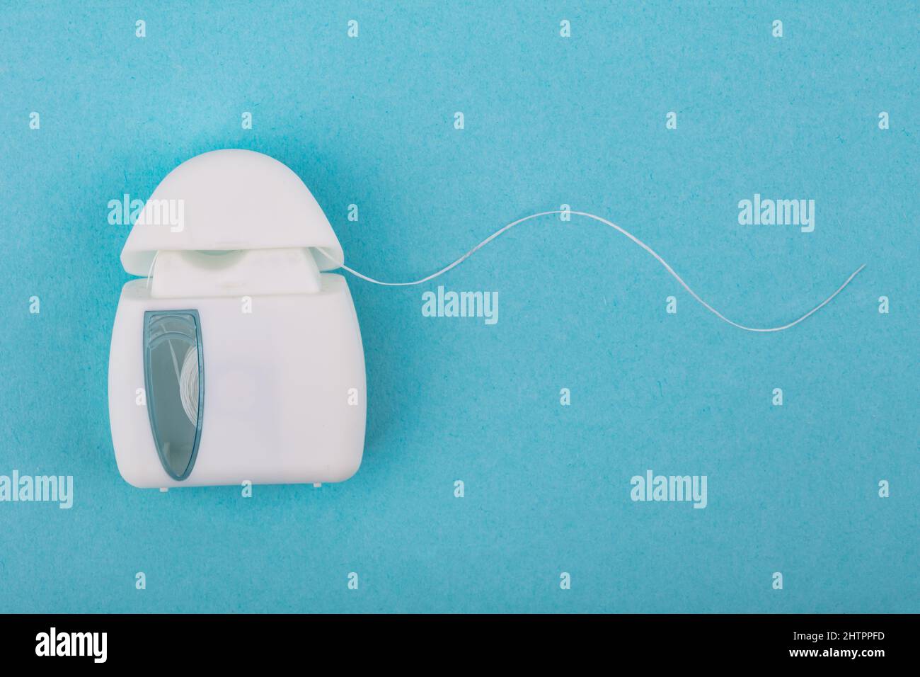 Concept dental Floss over light blue background Stock Photo - Alamy