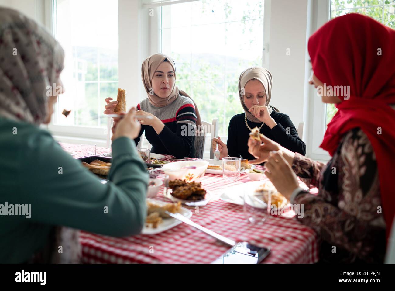 Muslim family and friends gathering together at home for eating dinner ...