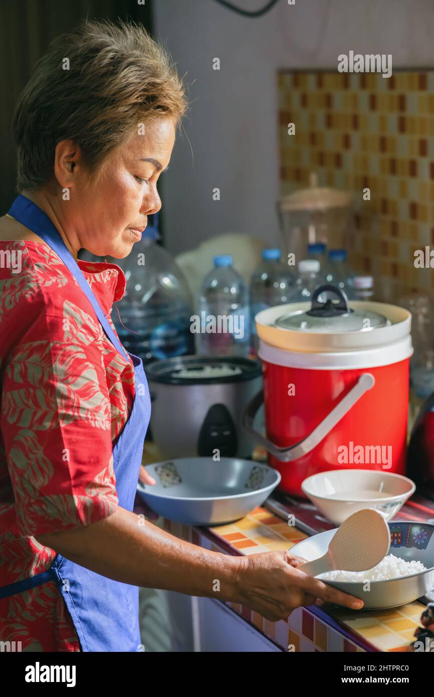 Thai beautiful woman cooking rice for family in the kitchen. Real ...