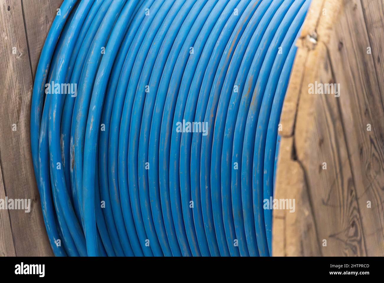 New blue power cable is wound on wooden coil. Background. Cable for ...