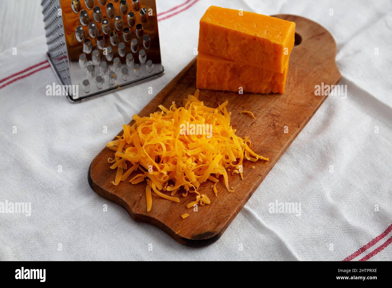 Shredded Sharp Cheddar Cheese on a rustic wooden board, side view Stock ...
