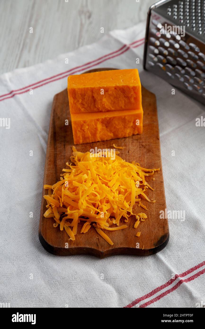 Shredded Sharp Cheddar Cheese on a rustic wooden board, side view Stock ...