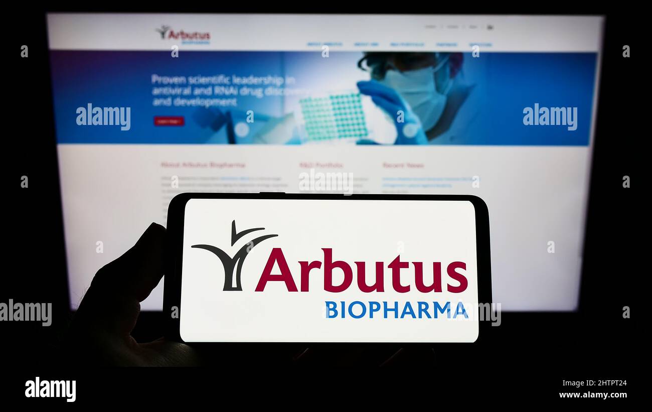 Person holding smartphone with logo of Canadian company Arbutus ...