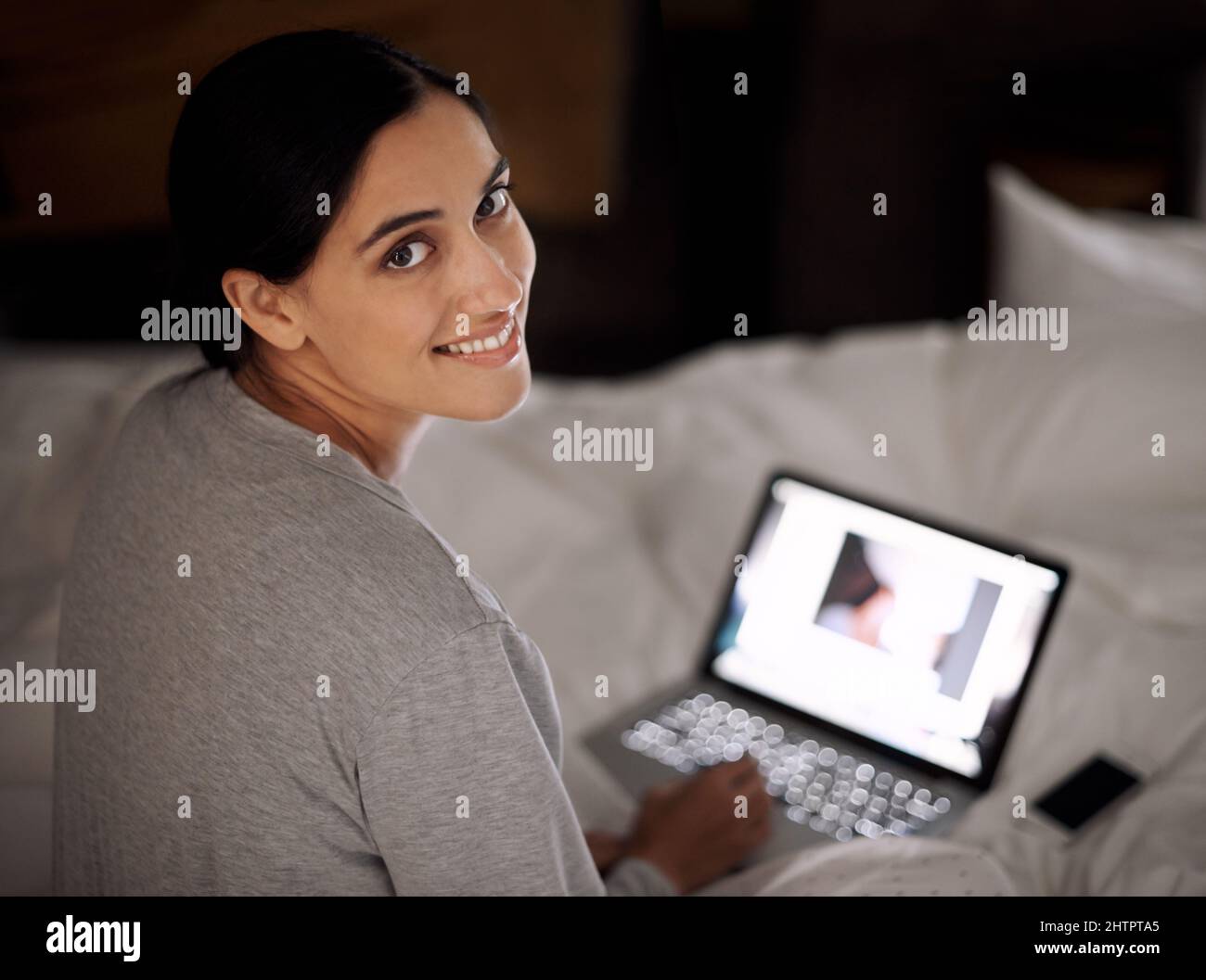 Catching up with an old friend. A young woman working on her laptop in ...
