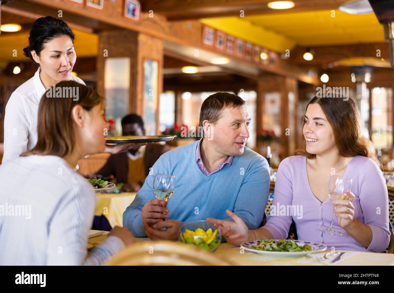 Happy friends meeting in restaurant during dinner Stock Photo - Alamy