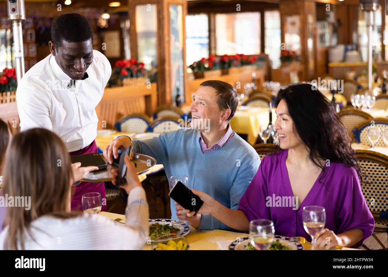 African American waiter brought mobile phones on the tray of restaurant ...