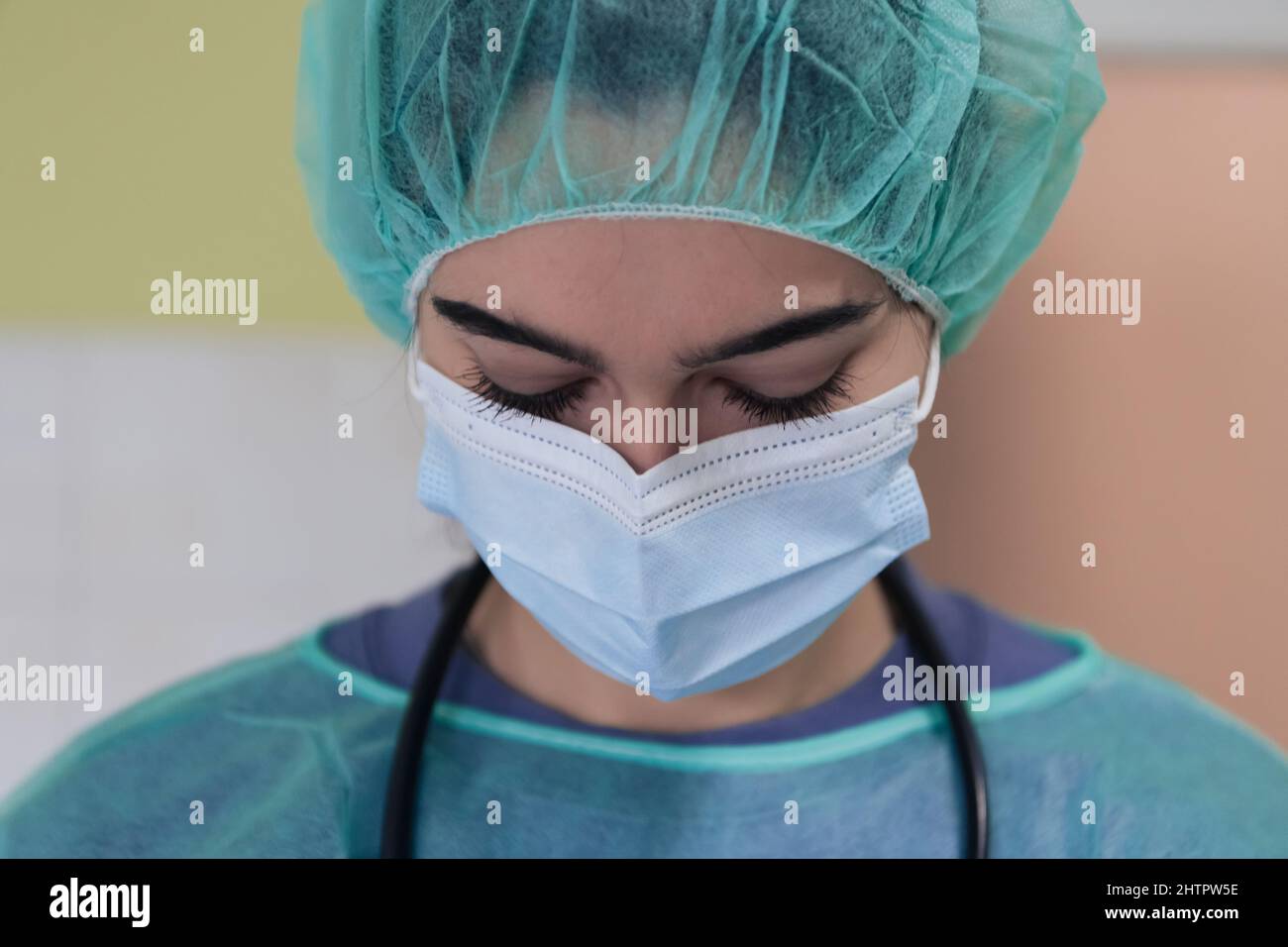 Portrait of sad and overwhelmed doctor wearing protective face mask ...