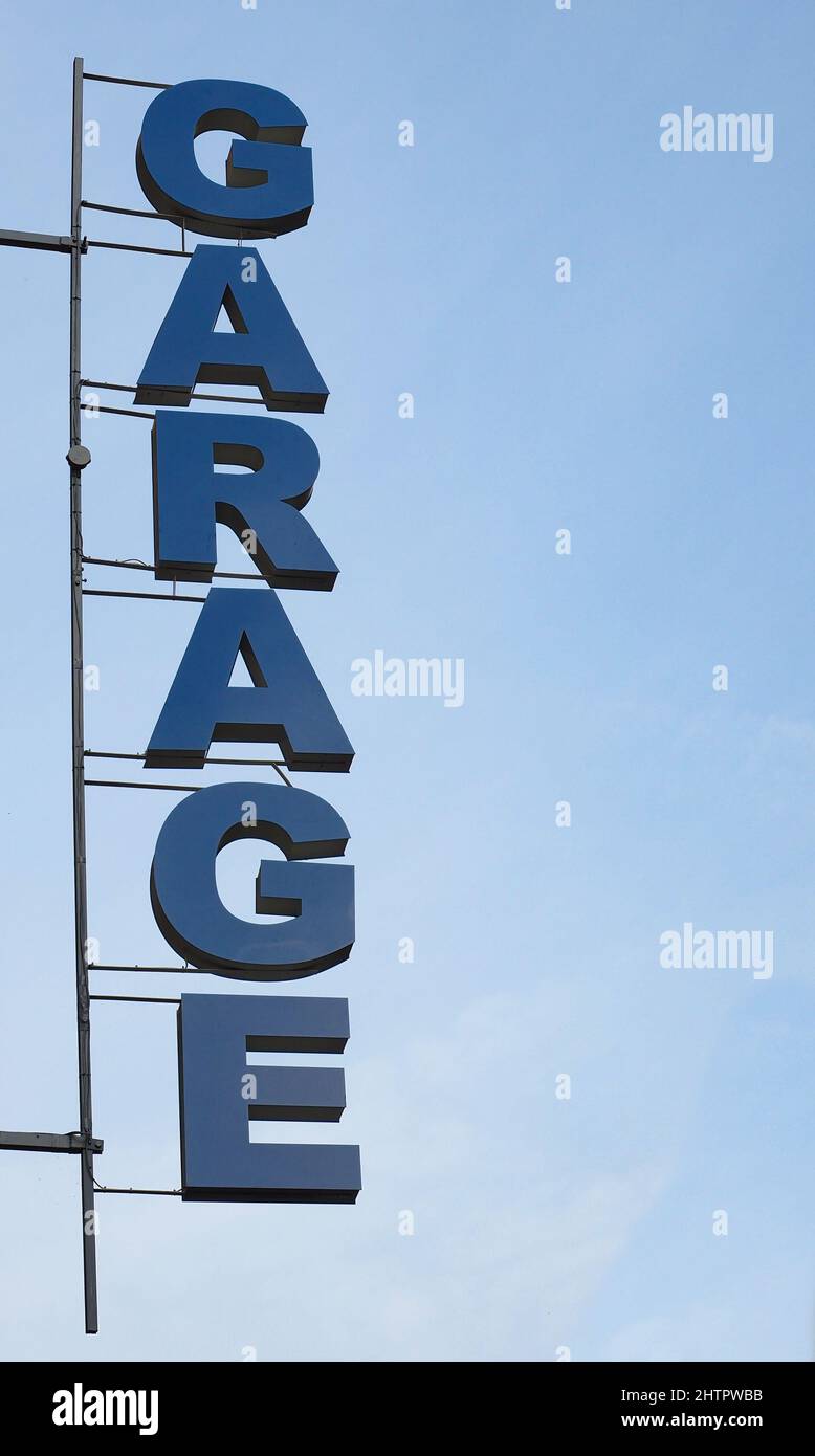 Blue neon light garage sign over blue sky Stock Photo - Alamy