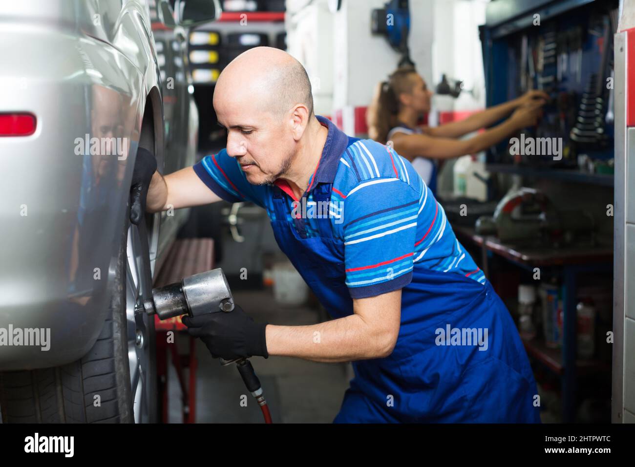 Man fitting new tyre hi-res stock photography and images - Alamy