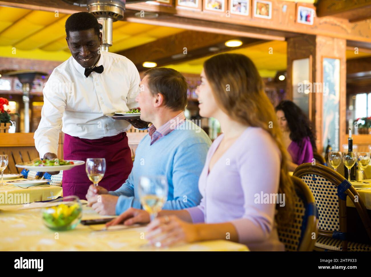 Waiter serving table for couple in restaurant Stock Photo - Alamy