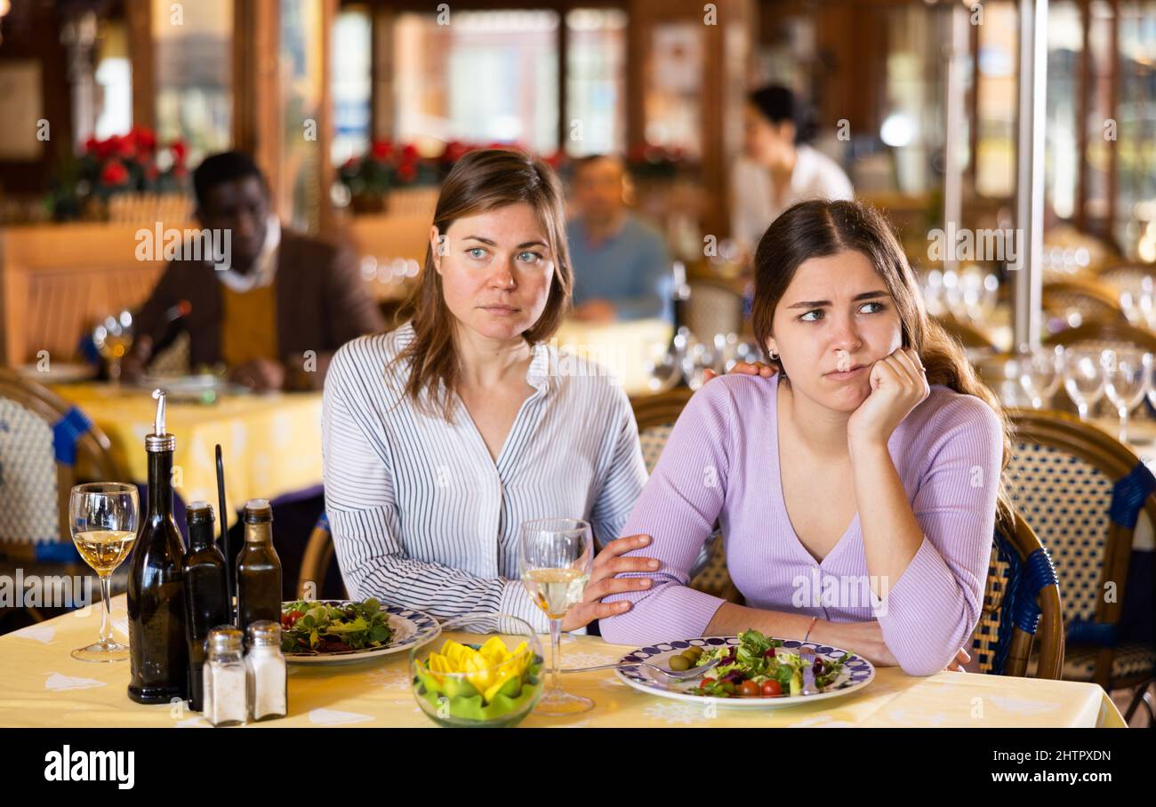 Woman calming her female friend down in restaurant Stock Photo - Alamy