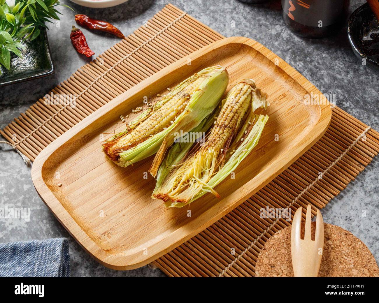 fresh young salted and boiled baby corn in wooden dish isolated mate ...