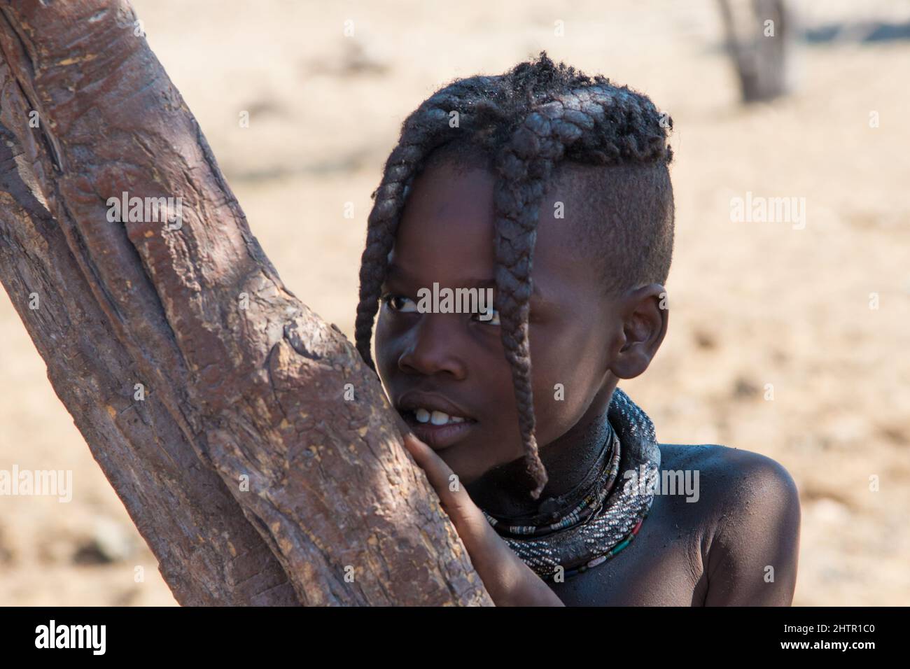 Closeup shot of an African child with hair braids looking side and ...