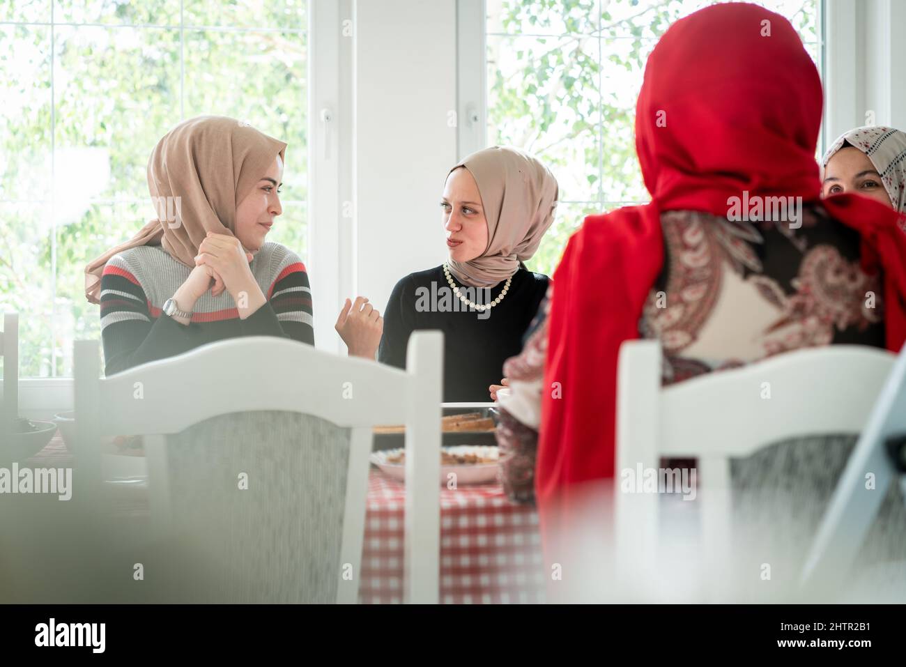 Muslim family and friends gathering together at home for eating dinner ...