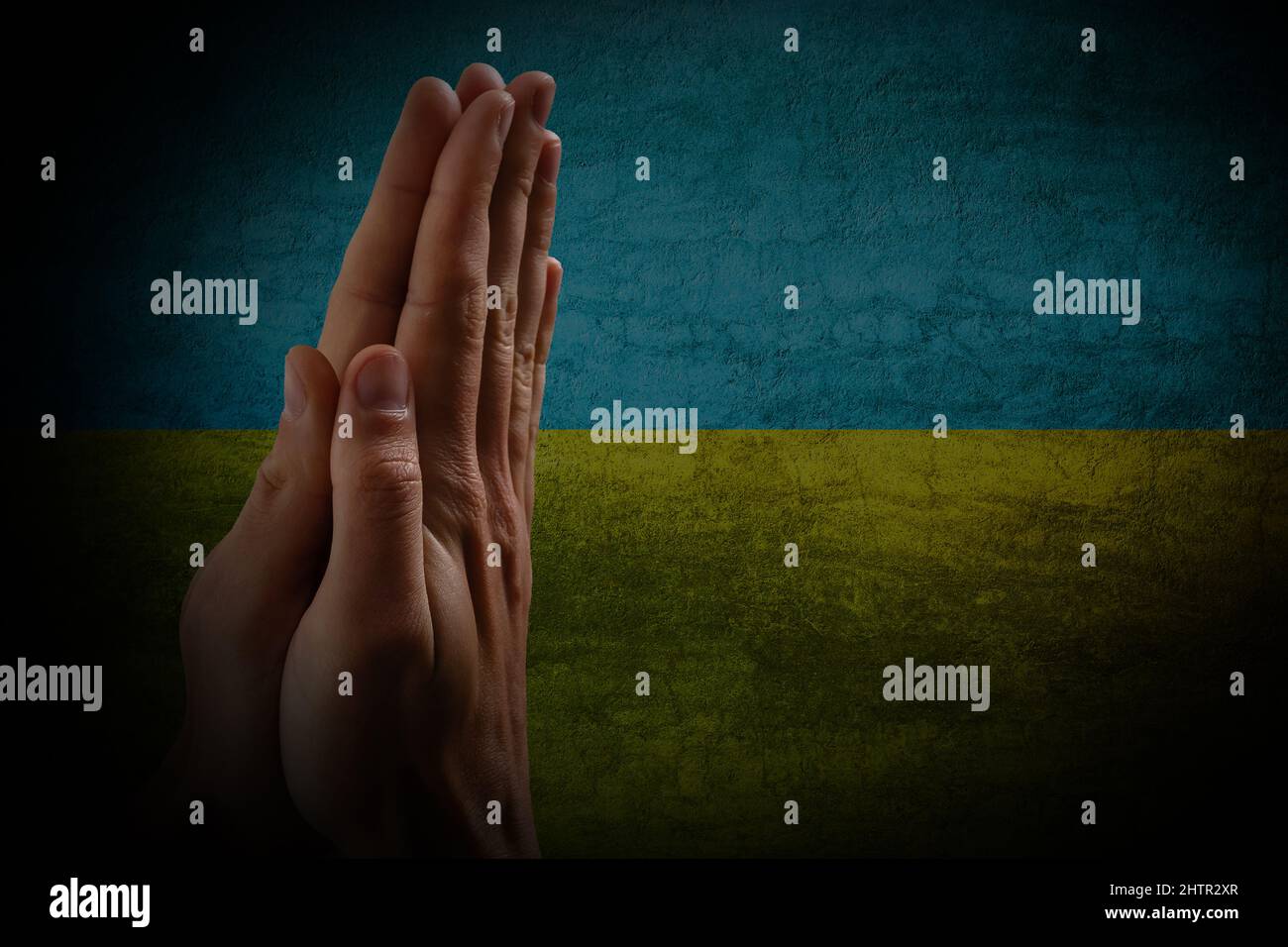 Pray for ukraine. hands pray on ukraine flag Stock Photo - Alamy