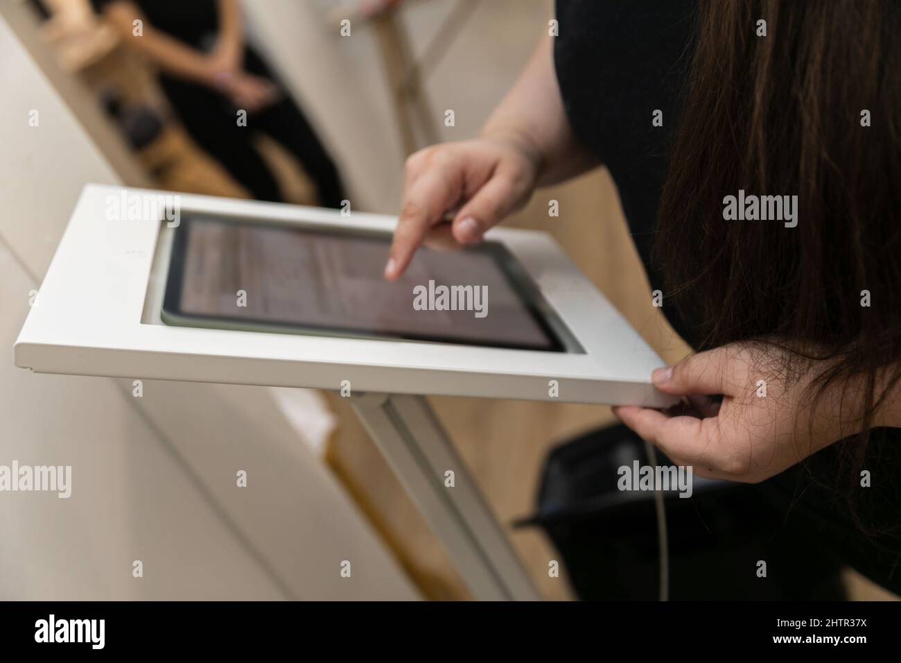 A woman checking in at a medical wellness spa using an electronic ...