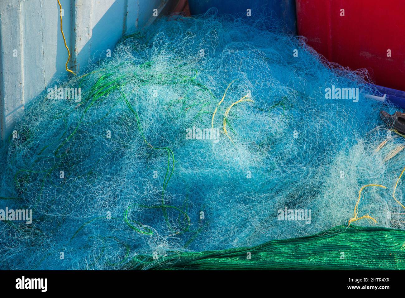 A fishing net with ropes and cord on the deck of a Fisherman's boat ...