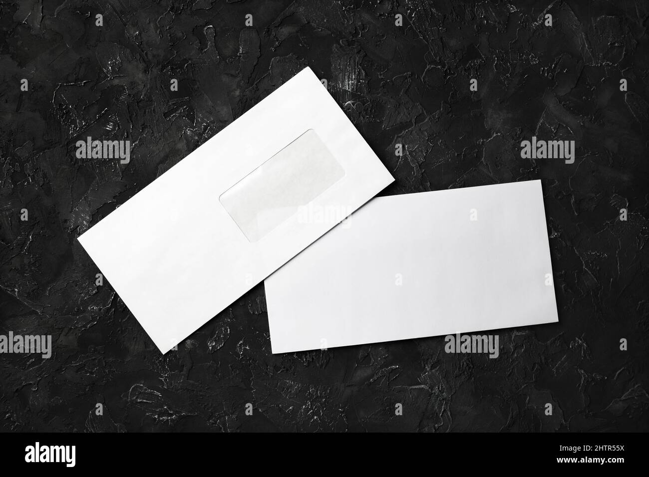 Blank white paper envelopes on black stone background. Front and back ...