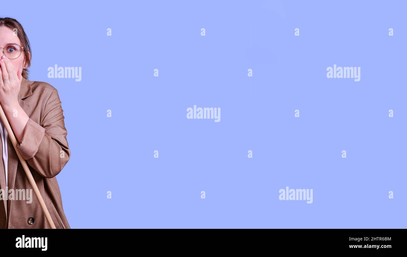 Scared woman teacher with pointer on studio blue background, banner ...