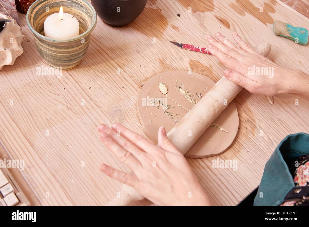rolling out the clay mass for sculpting a wall panel Stock Photo - Alamy