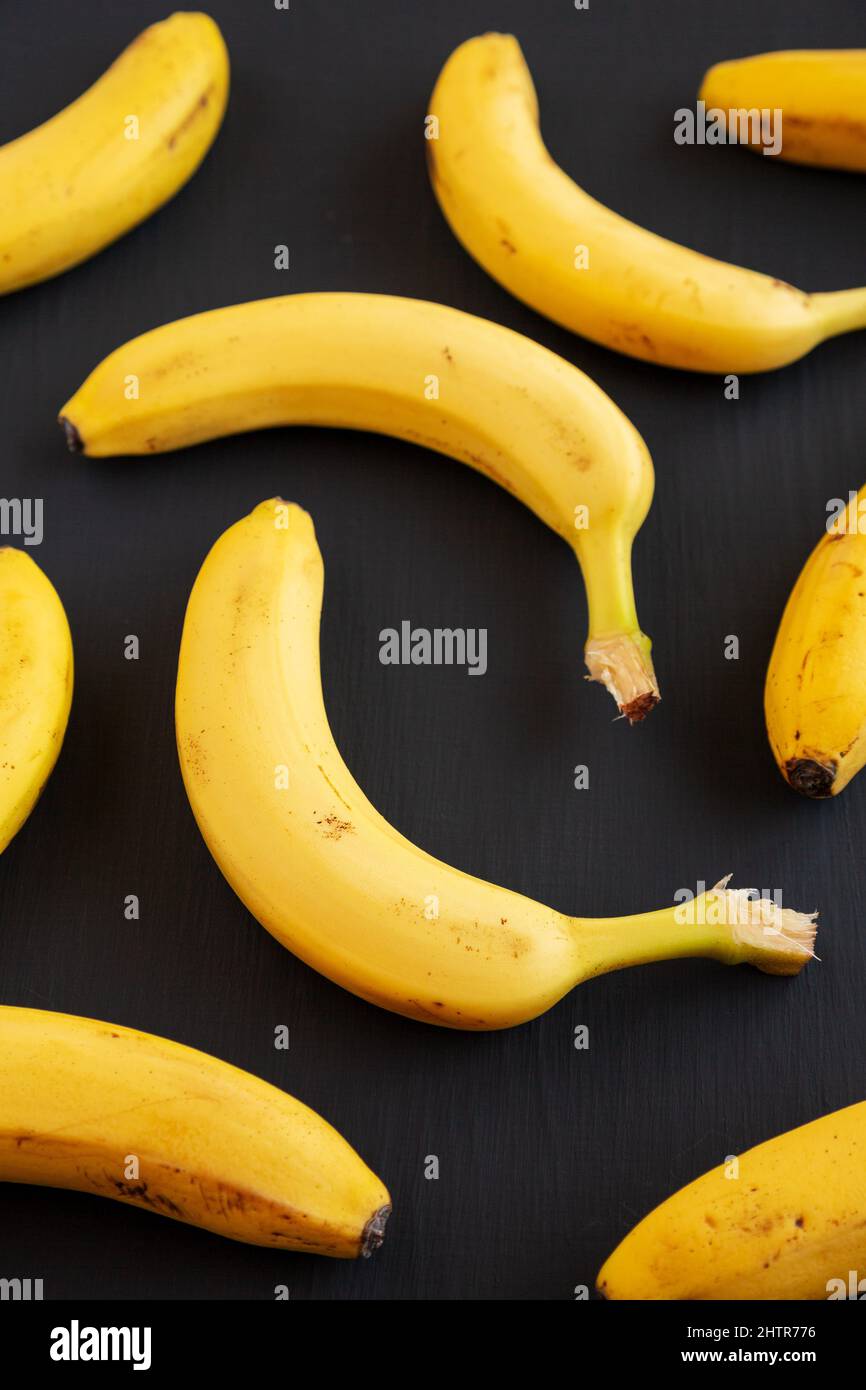 Raw Organic Bananas on black background, side view Stock Photo - Alamy