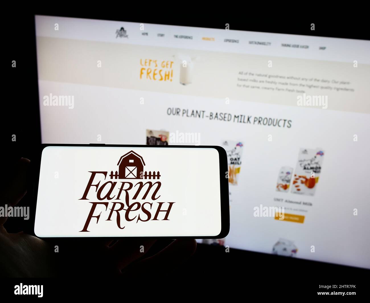 Person holding mobile phone with logo of Malaysian dairy company Farm ...