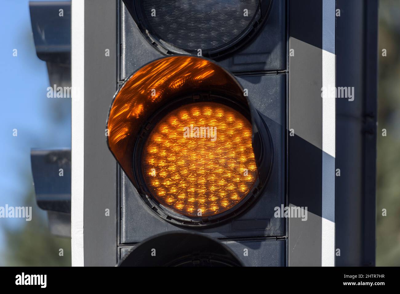 Traffic light with orange light against the evening sky Stock Photo - Alamy