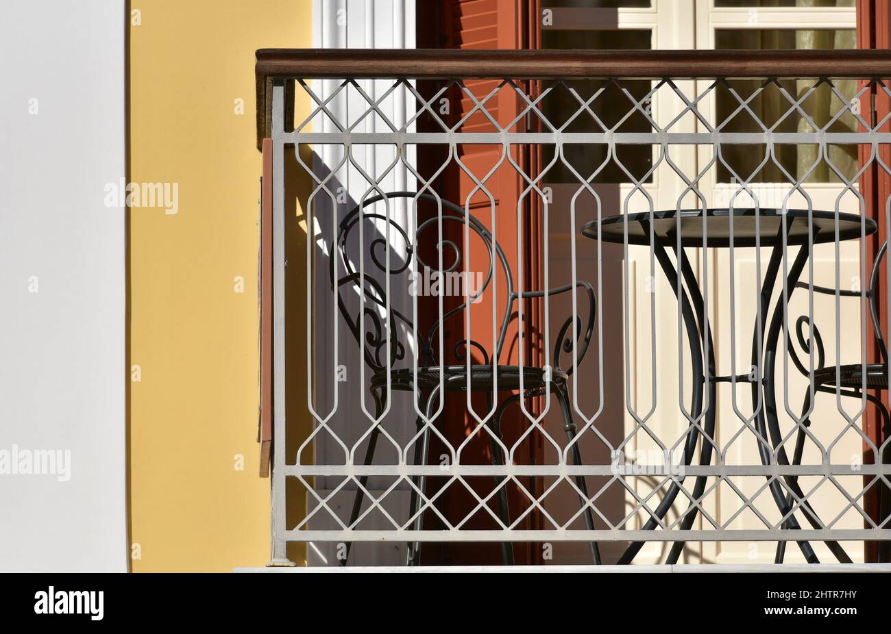 Traditional custom made wrought iron balcony railing against an ochre ...
