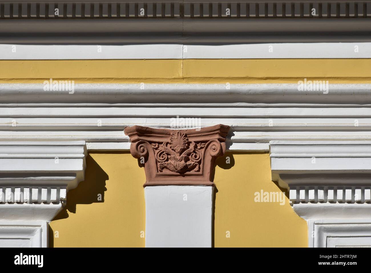 Old Neoclassical house facade with an ochre stucco wall, Ionic order ...