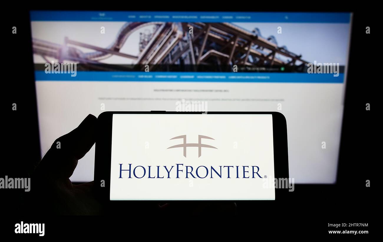 Person holding smartphone with logo of US petroleum company ...