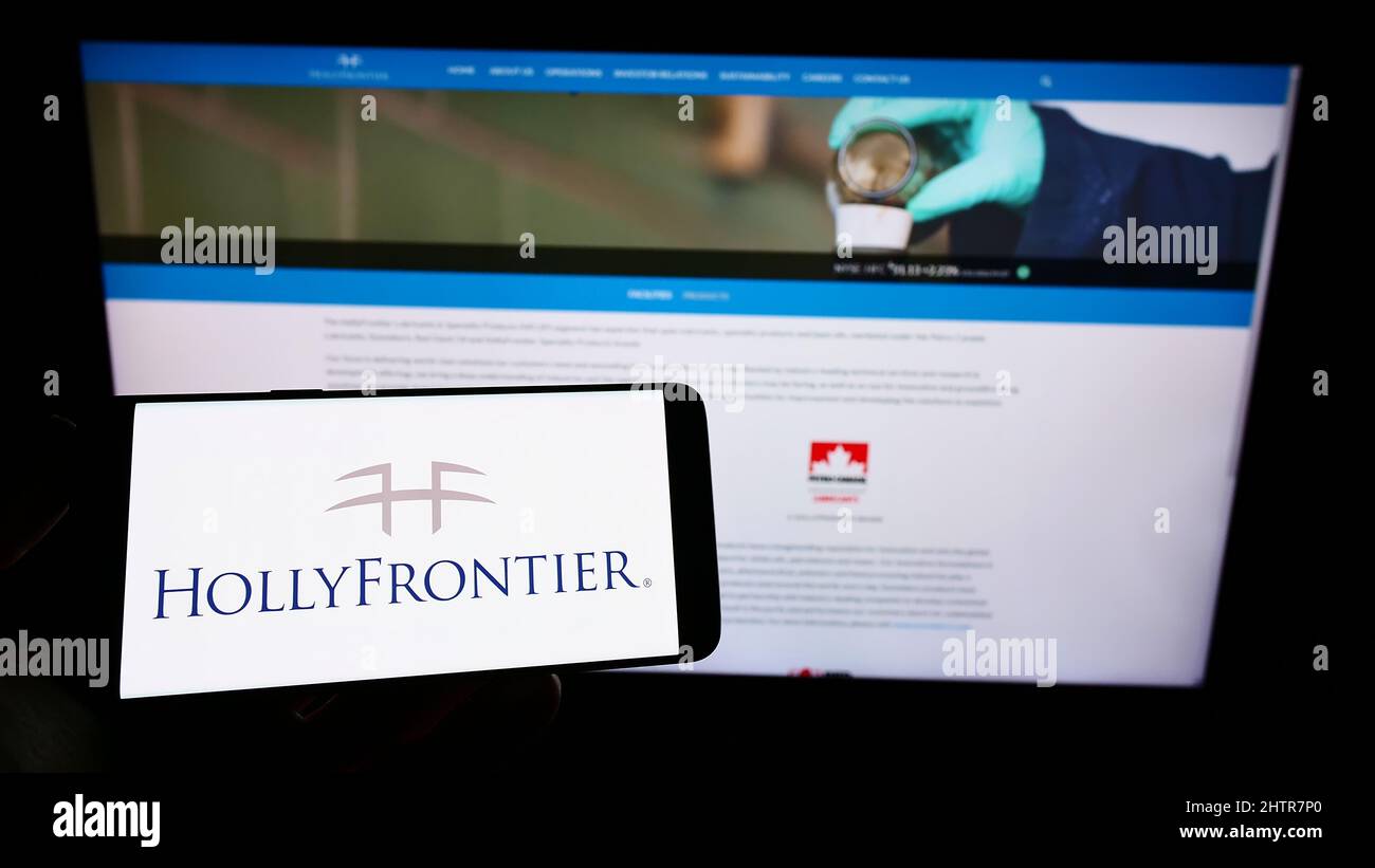 Person holding mobile phone with logo of US petroleum company ...